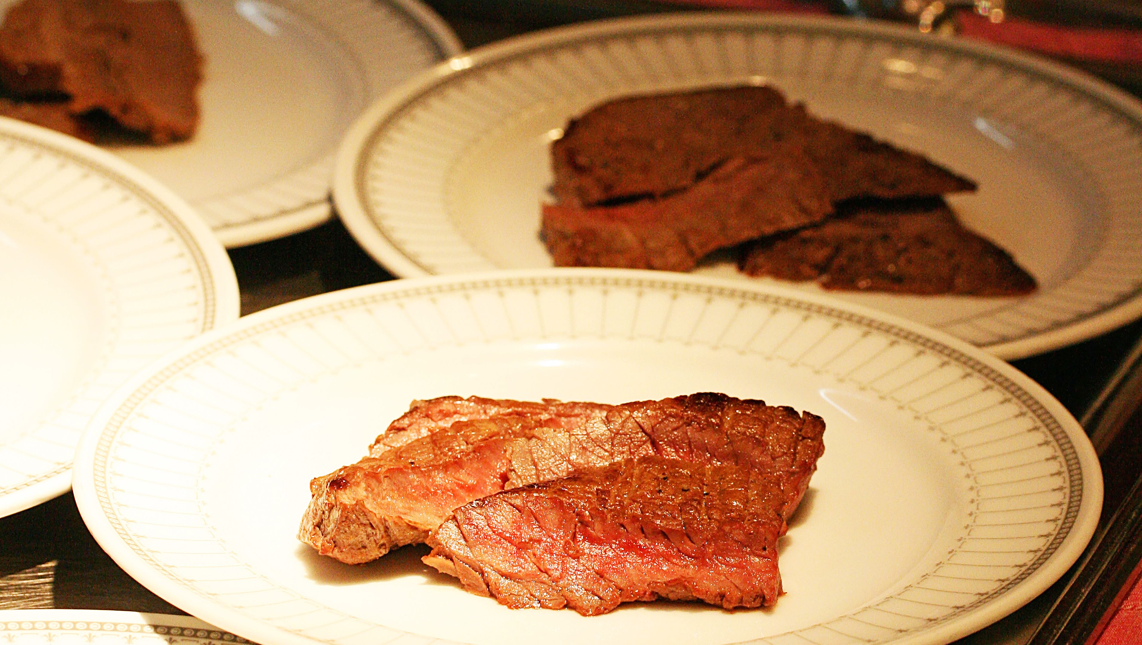 Um prato com um pedaço de carne grelhada.