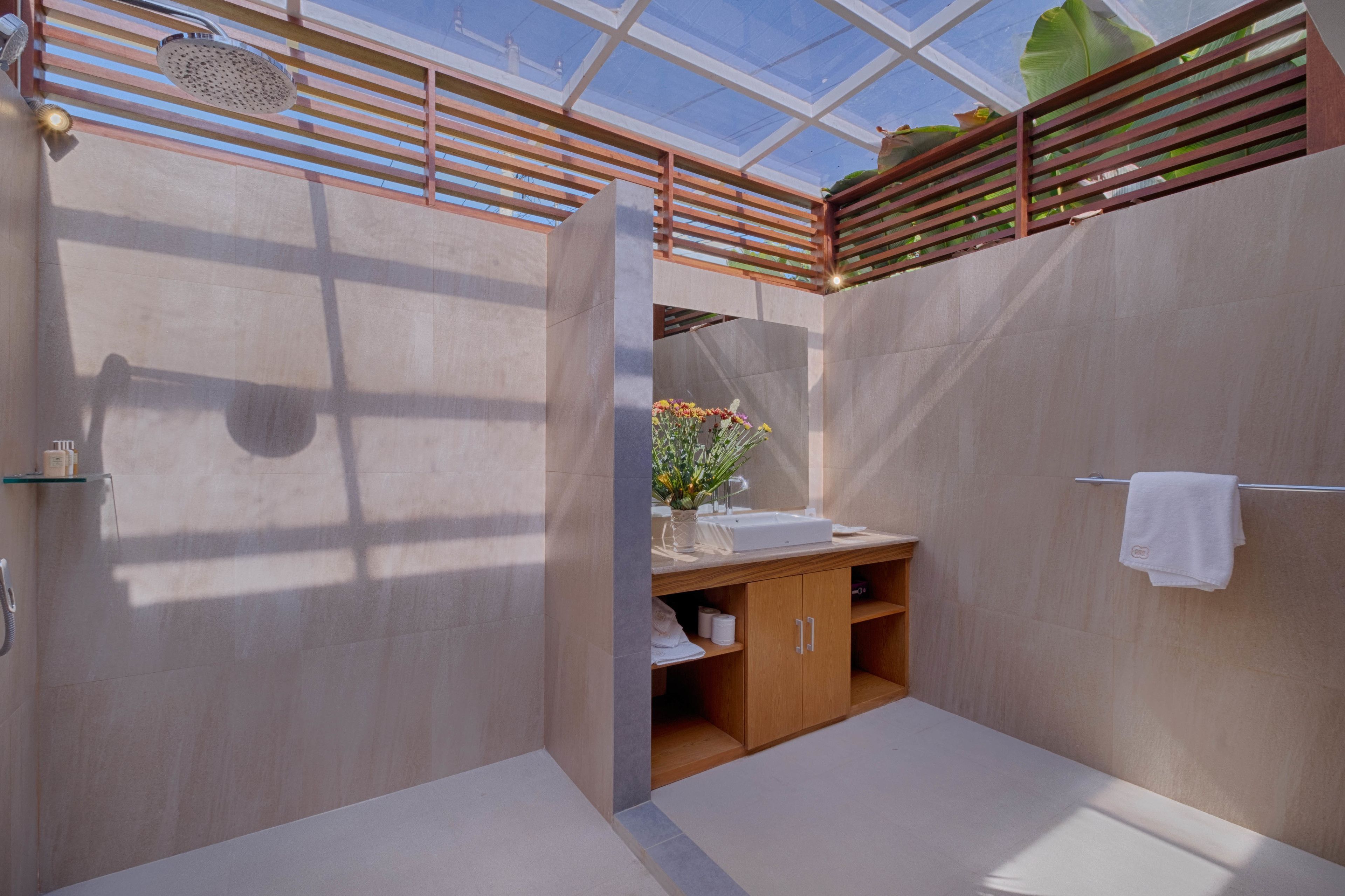 Uma casa de banho moderna com um claraboia, chuveiro e toucador com lavatório e porta-toalhas.