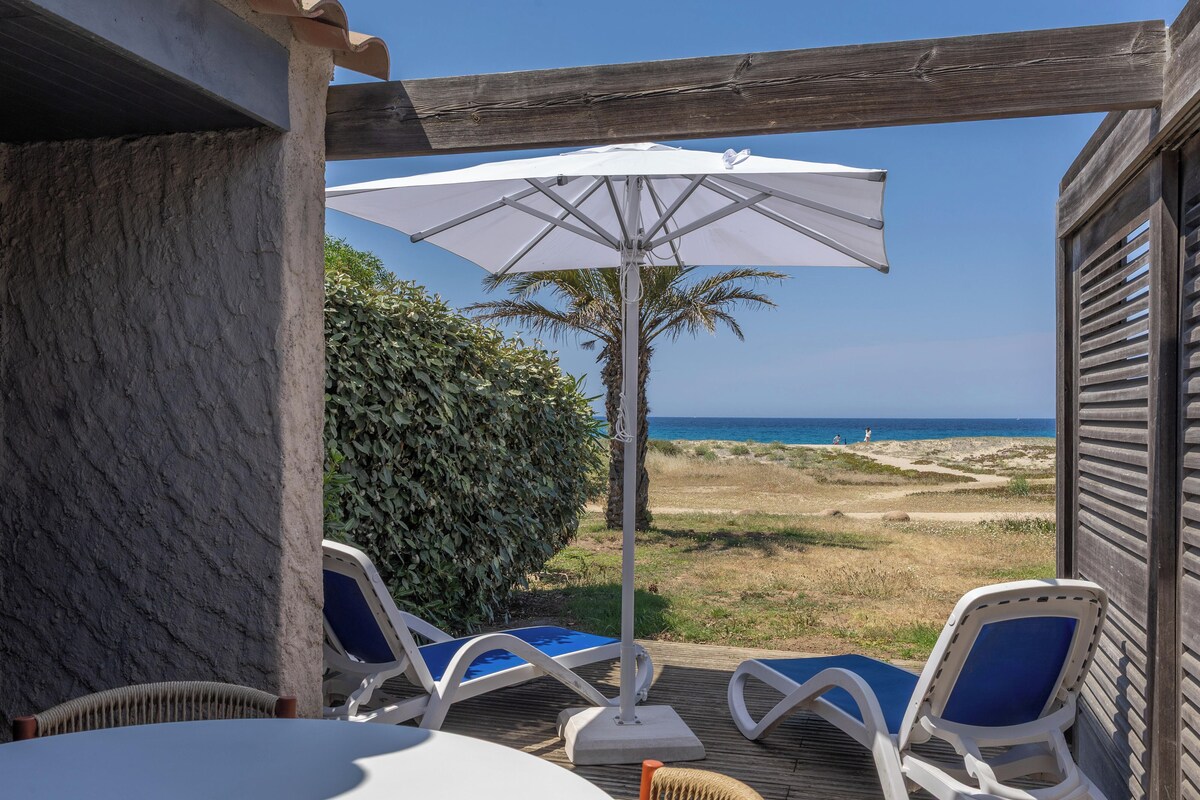 Área de estar coberta ao ar livre com vista para a praia e o oceano.