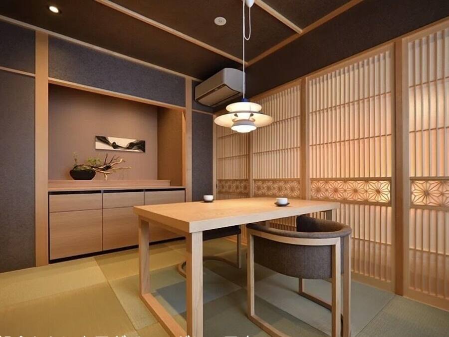 Um quarto japonês tradicional com tatames, uma mesa baixa, uma cadeira, um candeeiro pendente e um painel deslizante shoji.