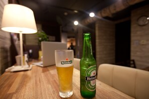 Uma mesa com um copo de cerveja e uma garrafa de Heineken.