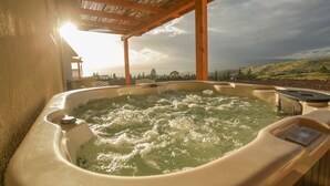 Uma banheira de hidromassagem com vista para uma paisagem e um céu nublado.