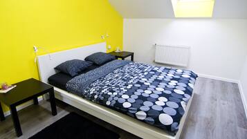 Um quarto moderno com uma cama, uma mesa de cabeceira, uma mesinha e um clarabóia.