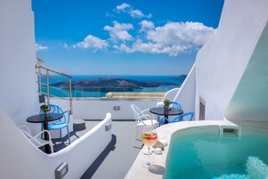 Varanda ensolarada com piscina, duas mesas com cadeiras e vista ampla do mar e ilhas ao longe.