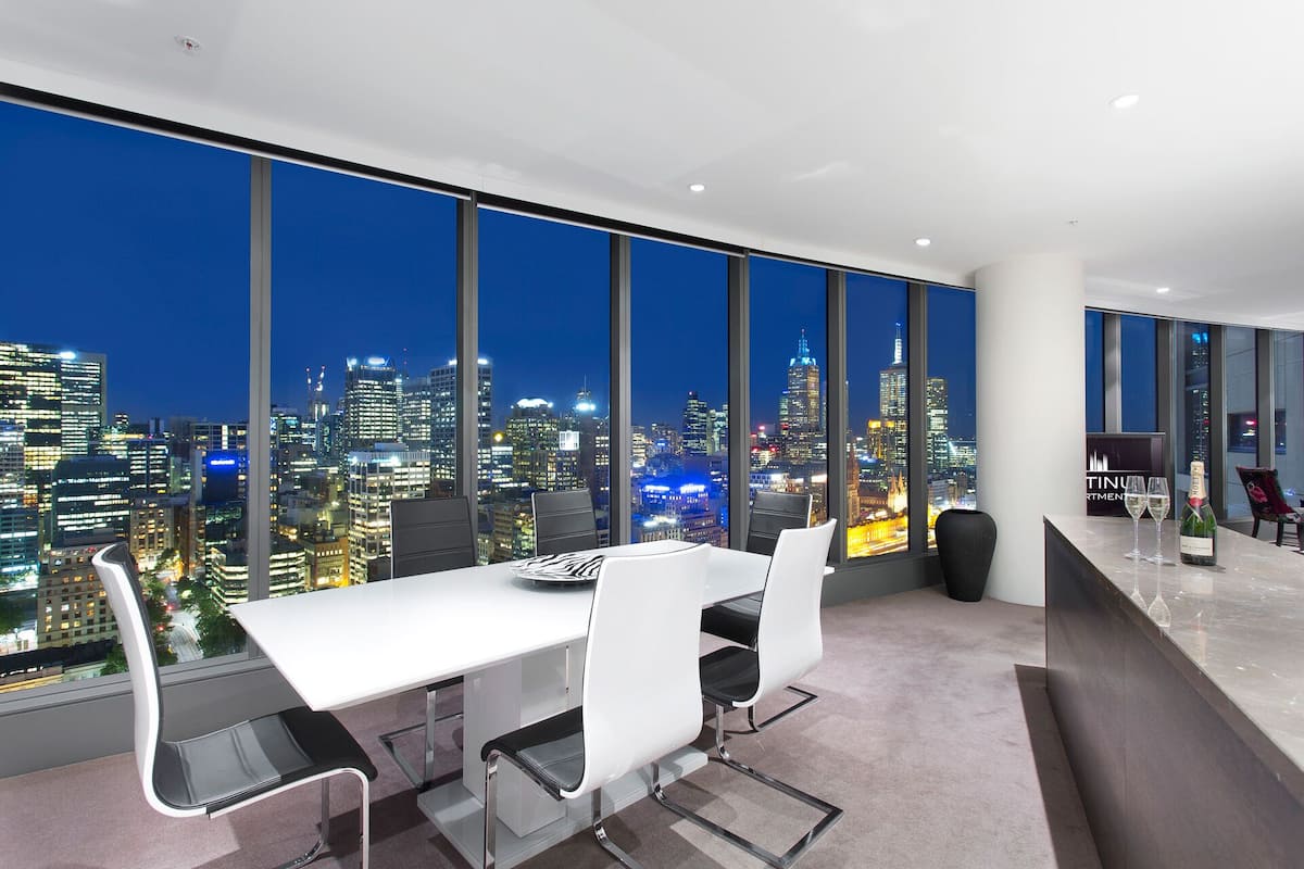 Uma sala de conferências moderna com vista panorâmica da cidade, janelas amplas e design minimalista.