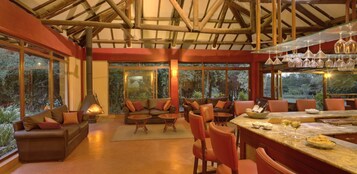 Um interior acolhedor com lareira, sofás de couro e um espaço de jantar com balcão.