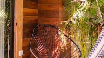 Uma cadeira-rede em um quarto de madeira com vista para o exterior.