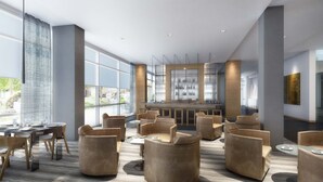 Uma área de estar moderna com sofás de couro, um bar com copos e grandes janelas com vista para o exterior.