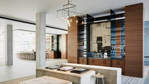 Uma cozinha moderna com eletrodomésticos embutidos, uma ilha central e uma área de jantar com uma mesa grande e cadeiras.