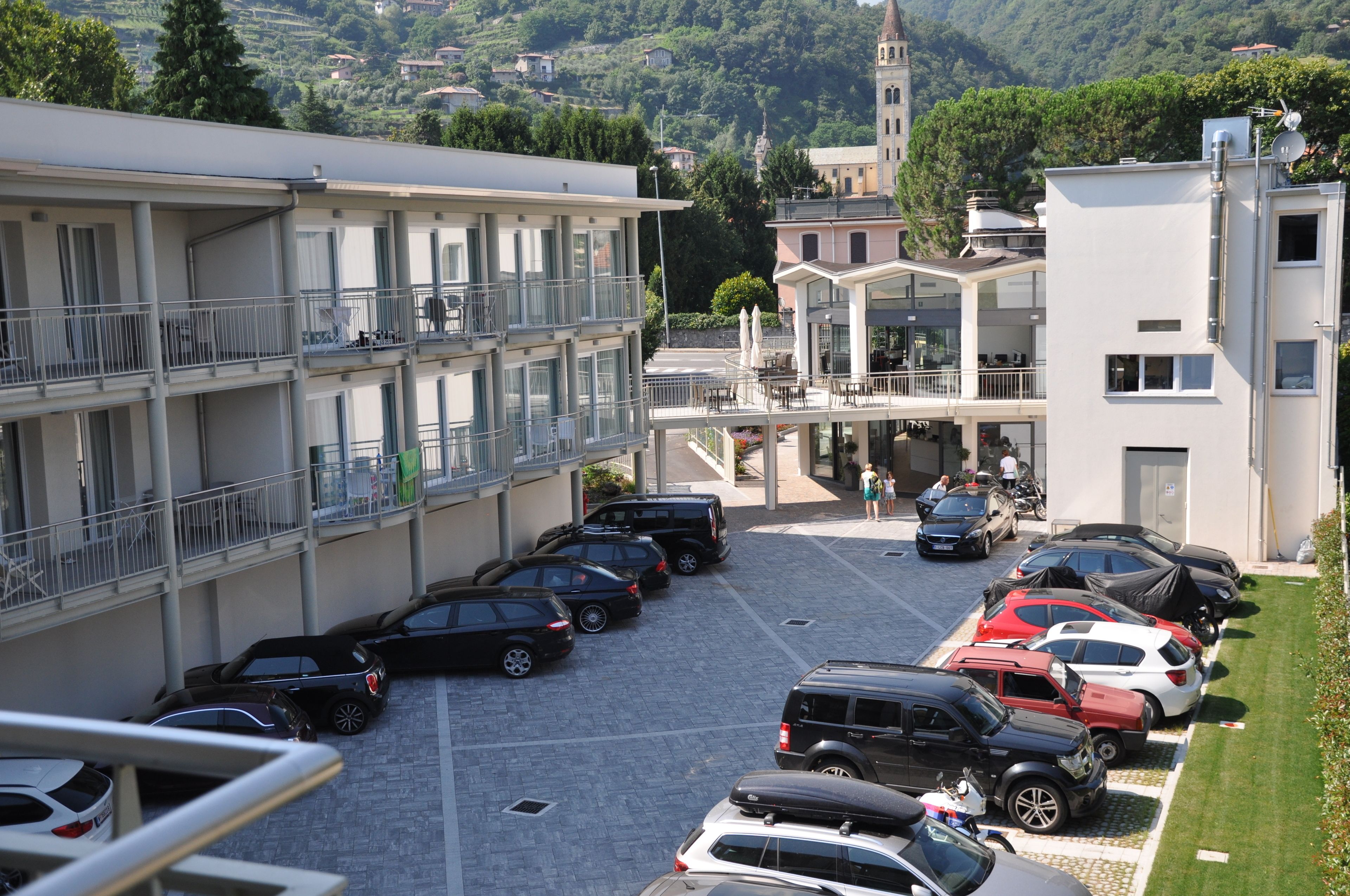 Um hotel com vários andares e um estacionamento cheio de carros.