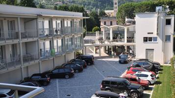 Um hotel com vários andares e um estacionamento cheio de carros.