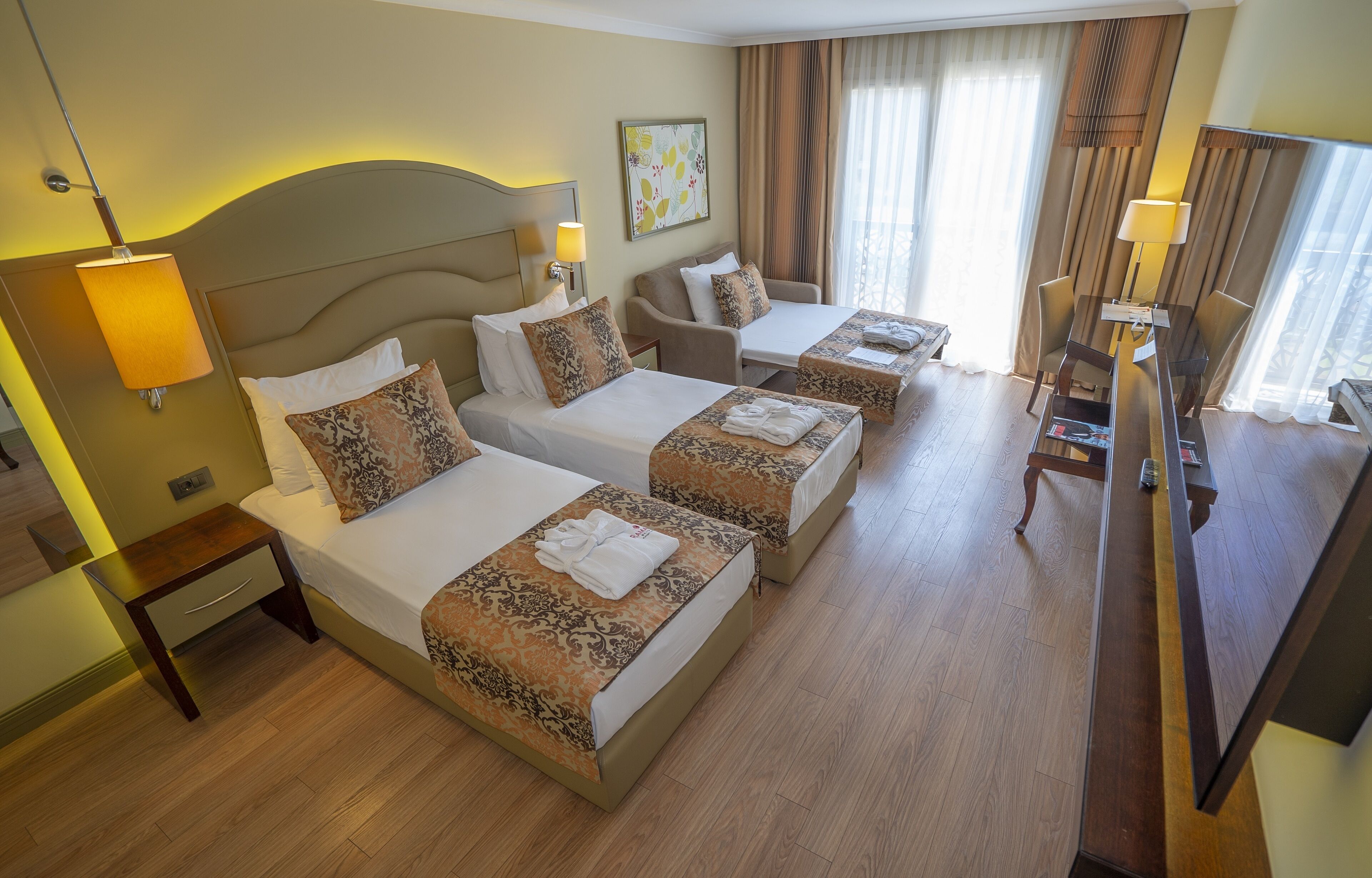Quarto de hotel com duas camas de solteiro, uma escrivaninha e uma cadeira.