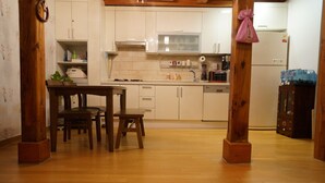 Uma cozinha com armários de madeira, uma mesa de jantar e cadeiras.