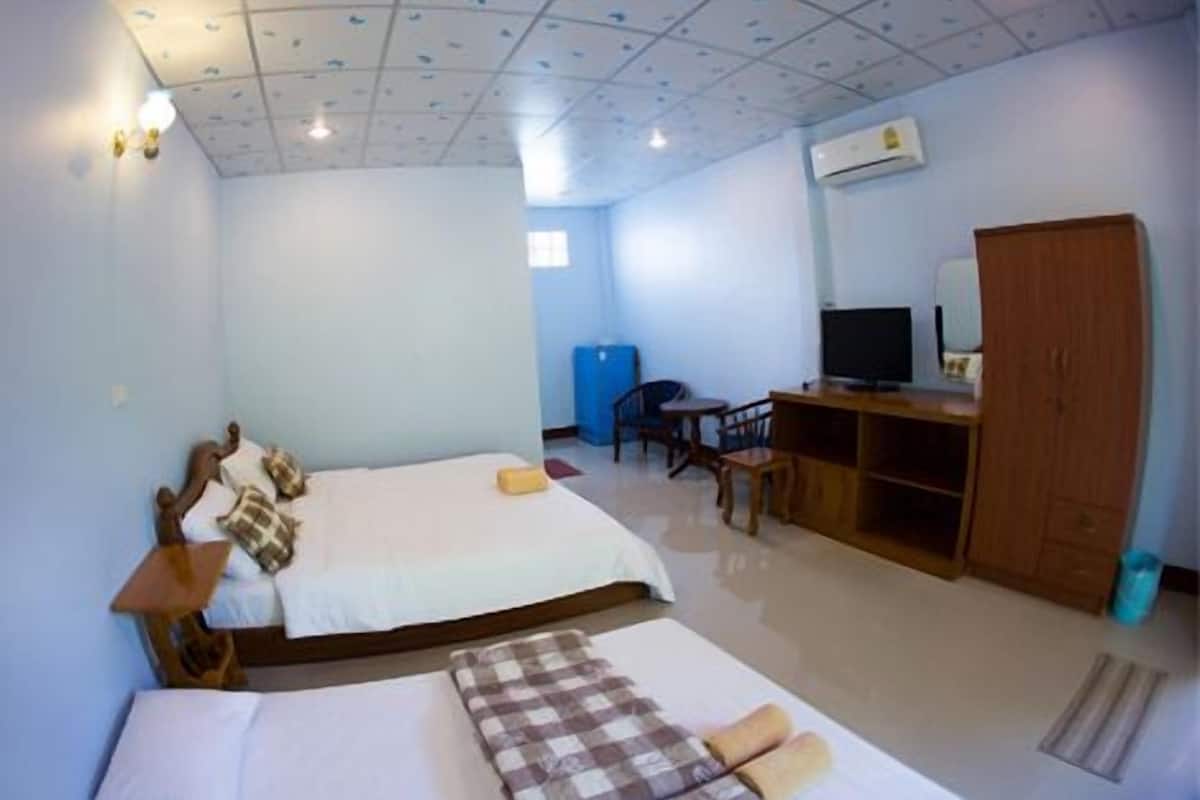 Quarto de hotel com duas camas, uma escrivaninha, uma televisão e aparelho de ar condicionado.