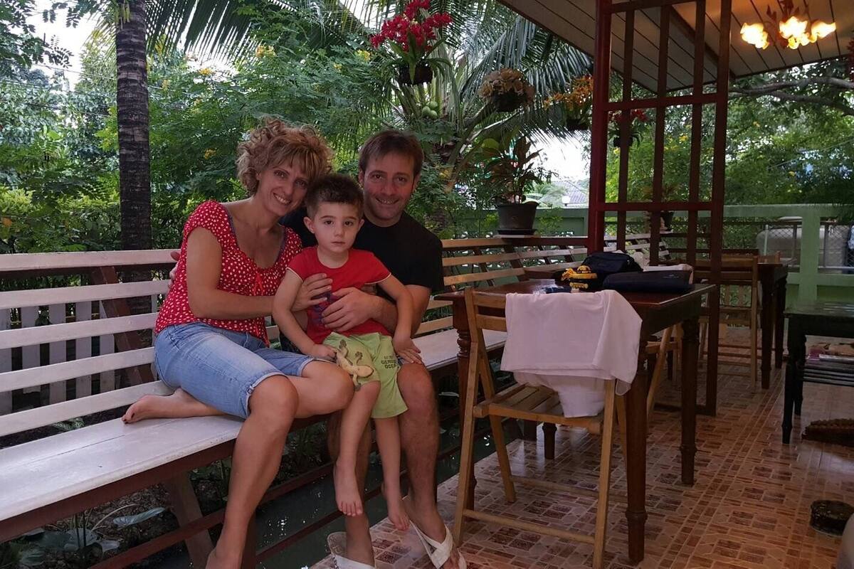 Um banco de madeira com uma mesa branca por perto.