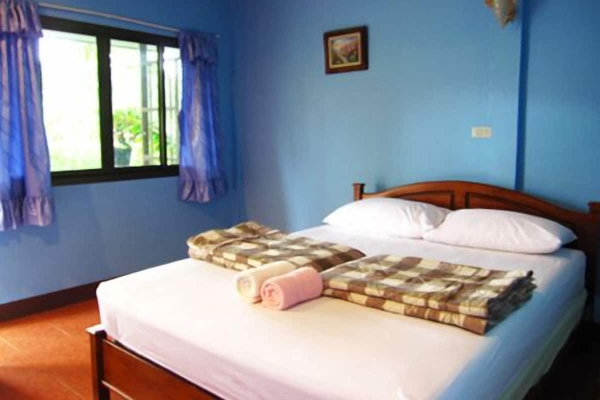 Um quarto com cama, cortinas e janela.
