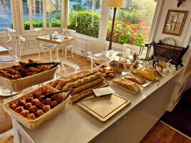 Um buffet de café da manhã com pães, doces e bebidas.