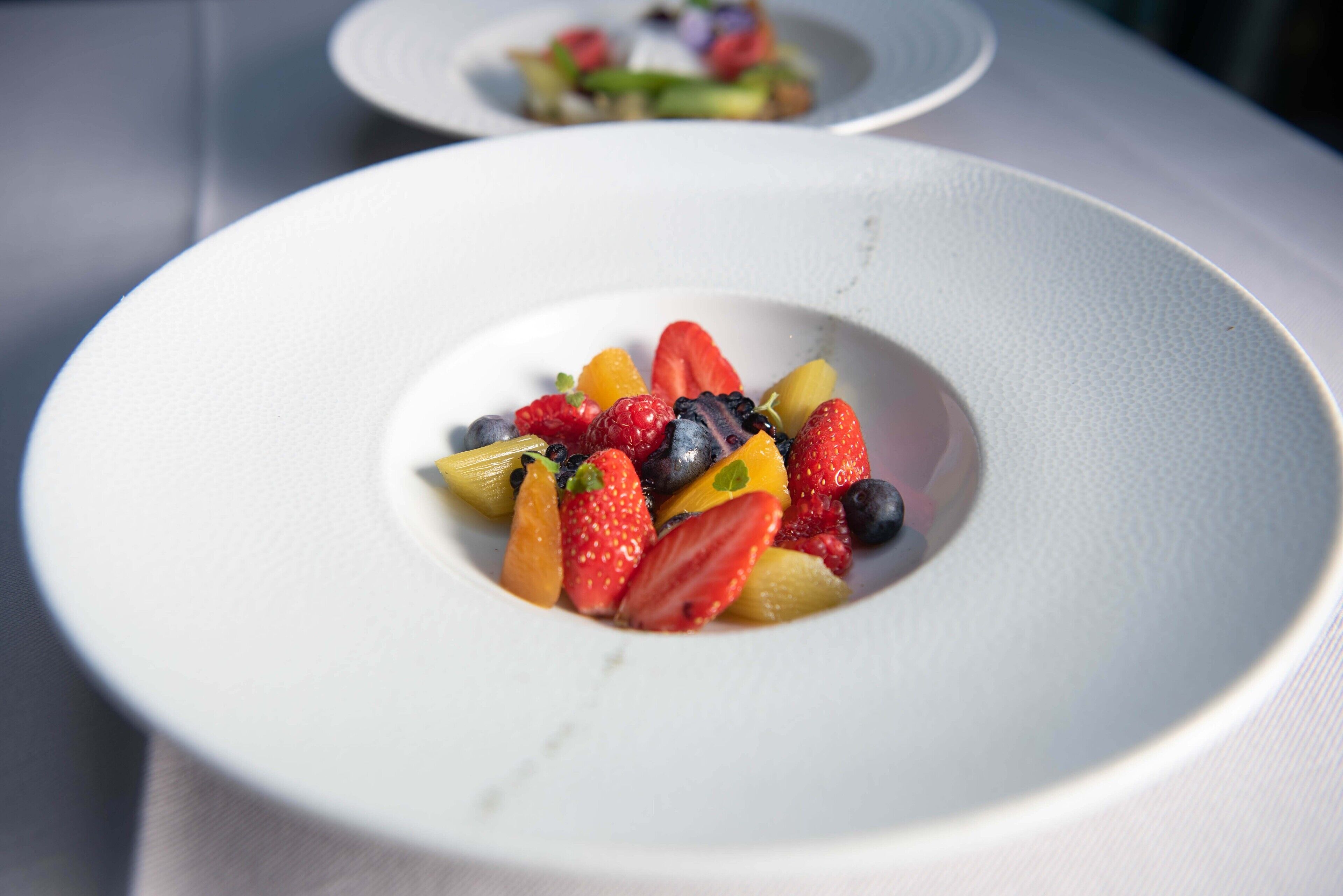 Um prato branco com salada de frutas.