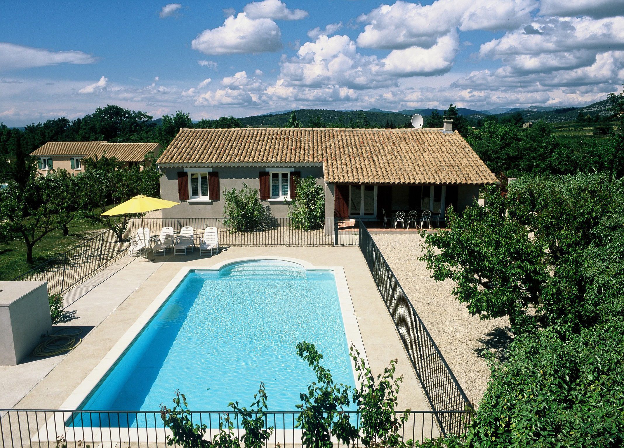 Uma villa com piscina, área de estar ao ar livre e vista para o campo.