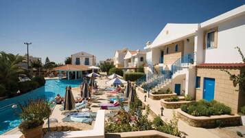 Um resort com piscina, espreguiçadeiras e escadaria que dá para um edifício.