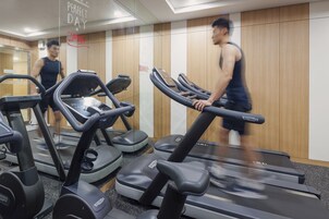 Uma academia com várias esteiras e equipamentos de ginástica.