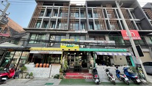 Um edifício de vários andares com uma fachada comercial no térreo.
