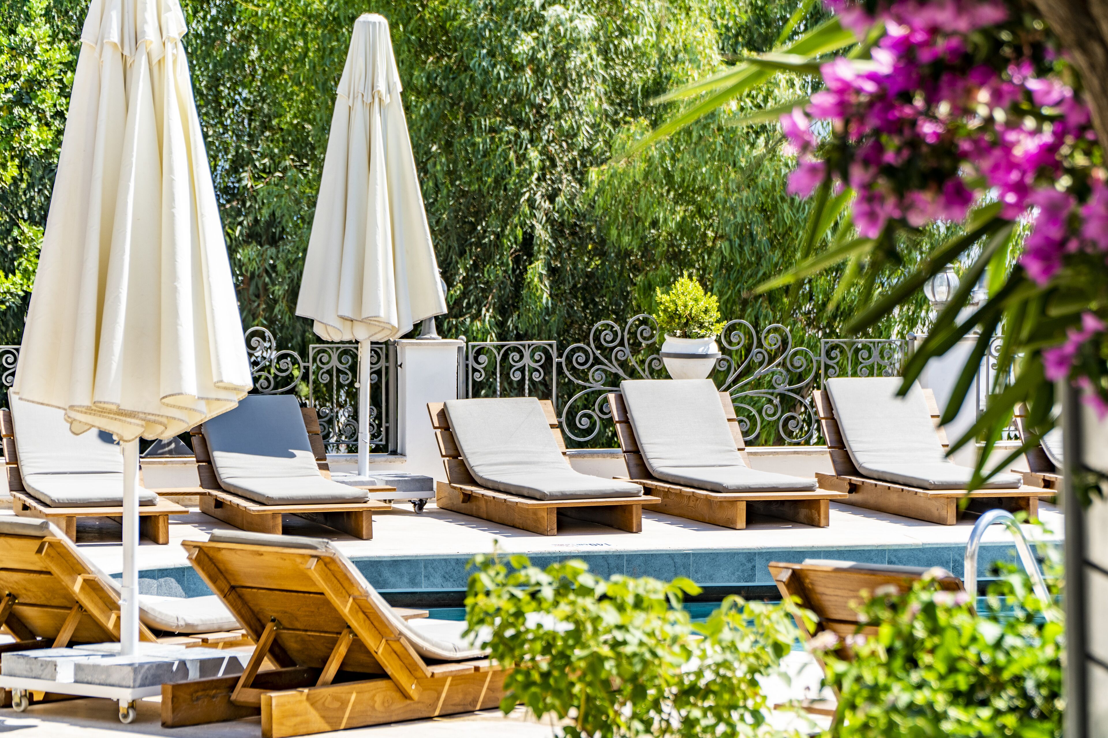 Uma área na piscina com espreguiçadeiras e guarda-sóis.