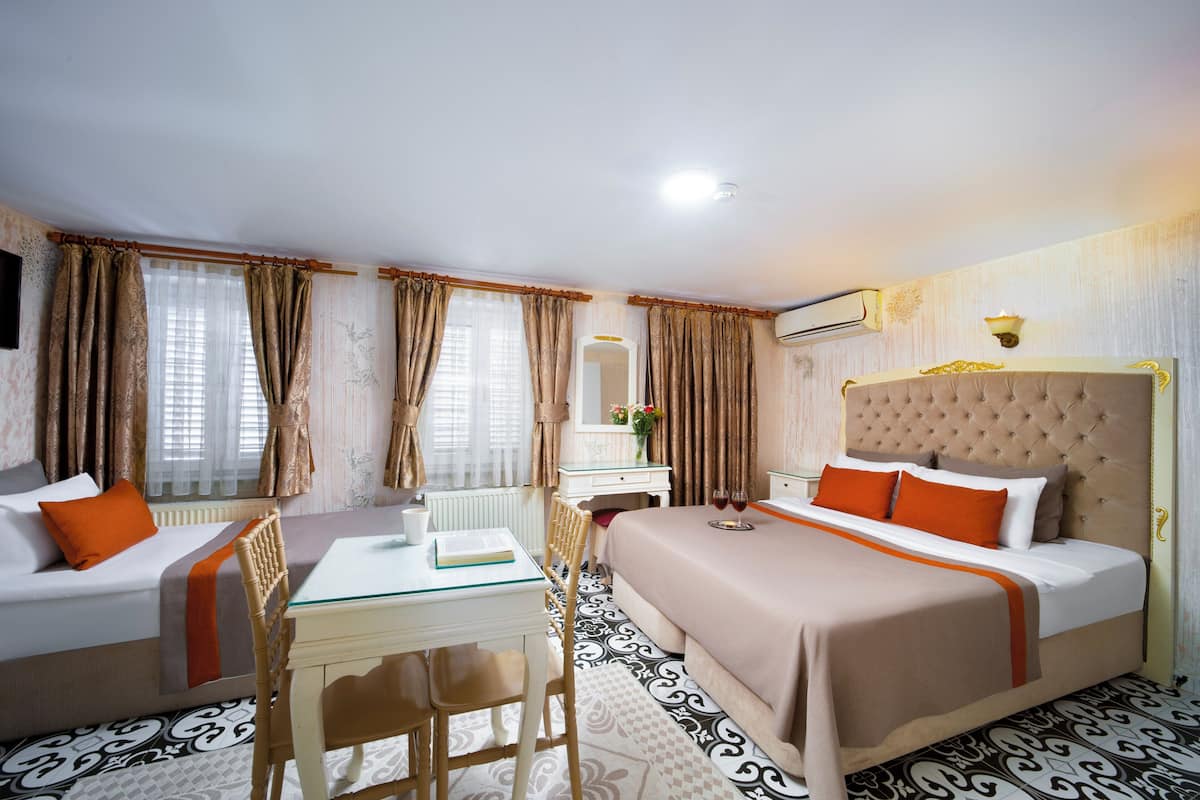 Quarto de hotel com cama, escrivaninha e cadeira.