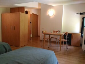 Quarto com cama, escrivaninha, cadeira e guarda-roupa.