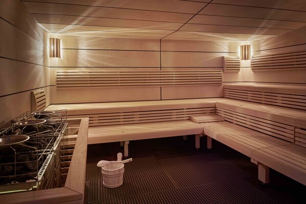 Uma sauna com bancos, um forno e um balde.
