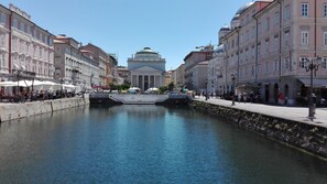 Um canal com edifícios em ambos os lados, uma ponte e um edifício central com cúpula.