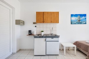 Apartamento, 2 quartos, varanda, vista para o jardim | Cozinha privada | Um frigorífico, uma placa de cozinha, uma cafeteira/bule 
