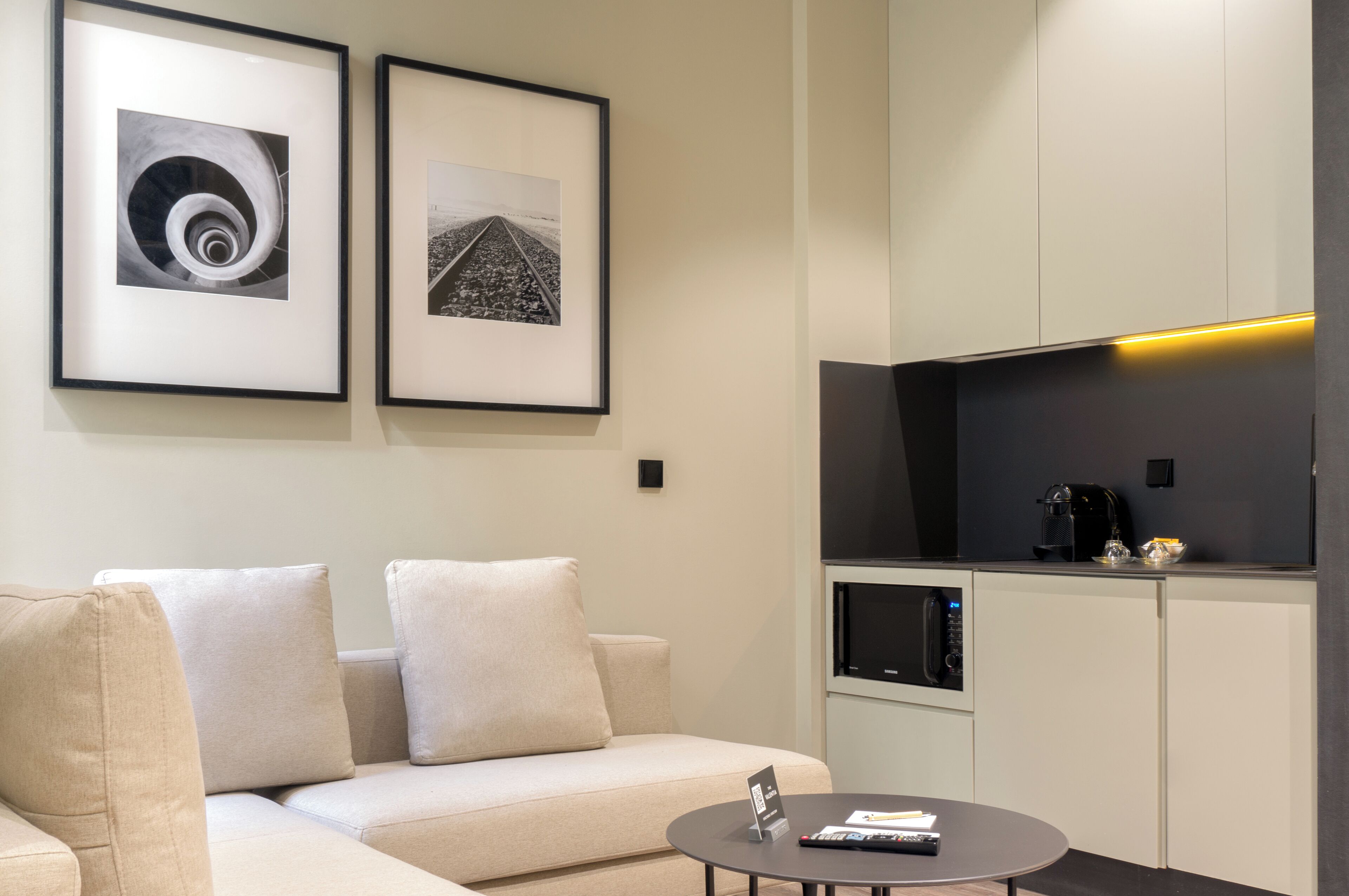 Uma sala de estar moderna com um sofá, uma mesa de centro e quadros nas paredes.