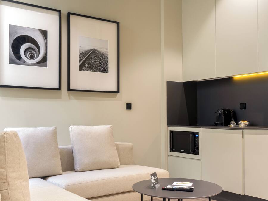 Uma sala de estar moderna com um sofá, uma mesa de centro e quadros nas paredes.