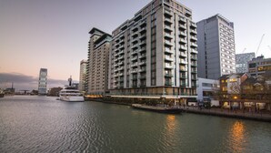 Um hotel moderno com vários andares, vista para o mar e design arquitetônico contemporâneo.