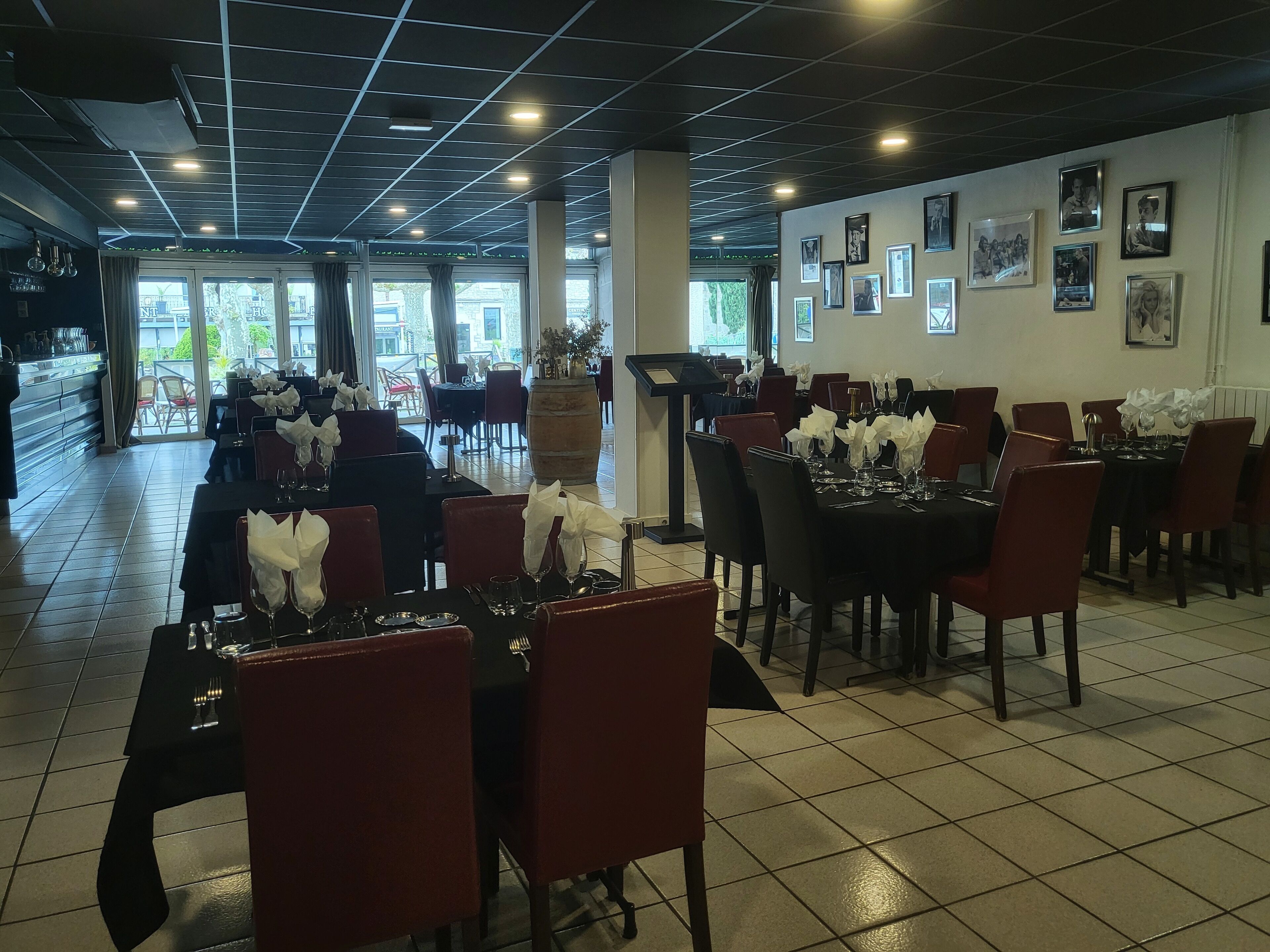Restaurante com mesas postas, cadeiras e um suporte para cardápio.