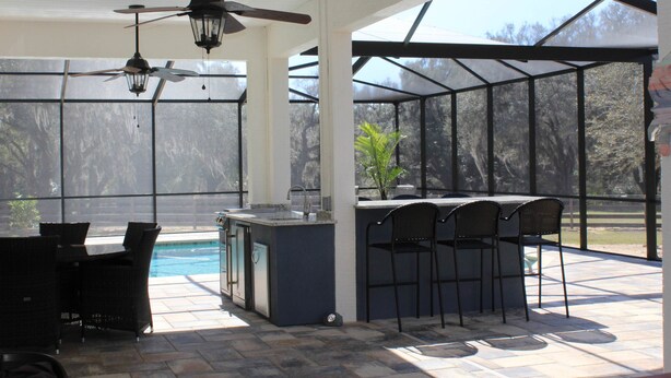 Estar coberto com piscina, área de bar e mobiliário para áreas externas.