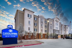 Um hotel de vários andares com uma placa de destaque para Candlewood Suites.