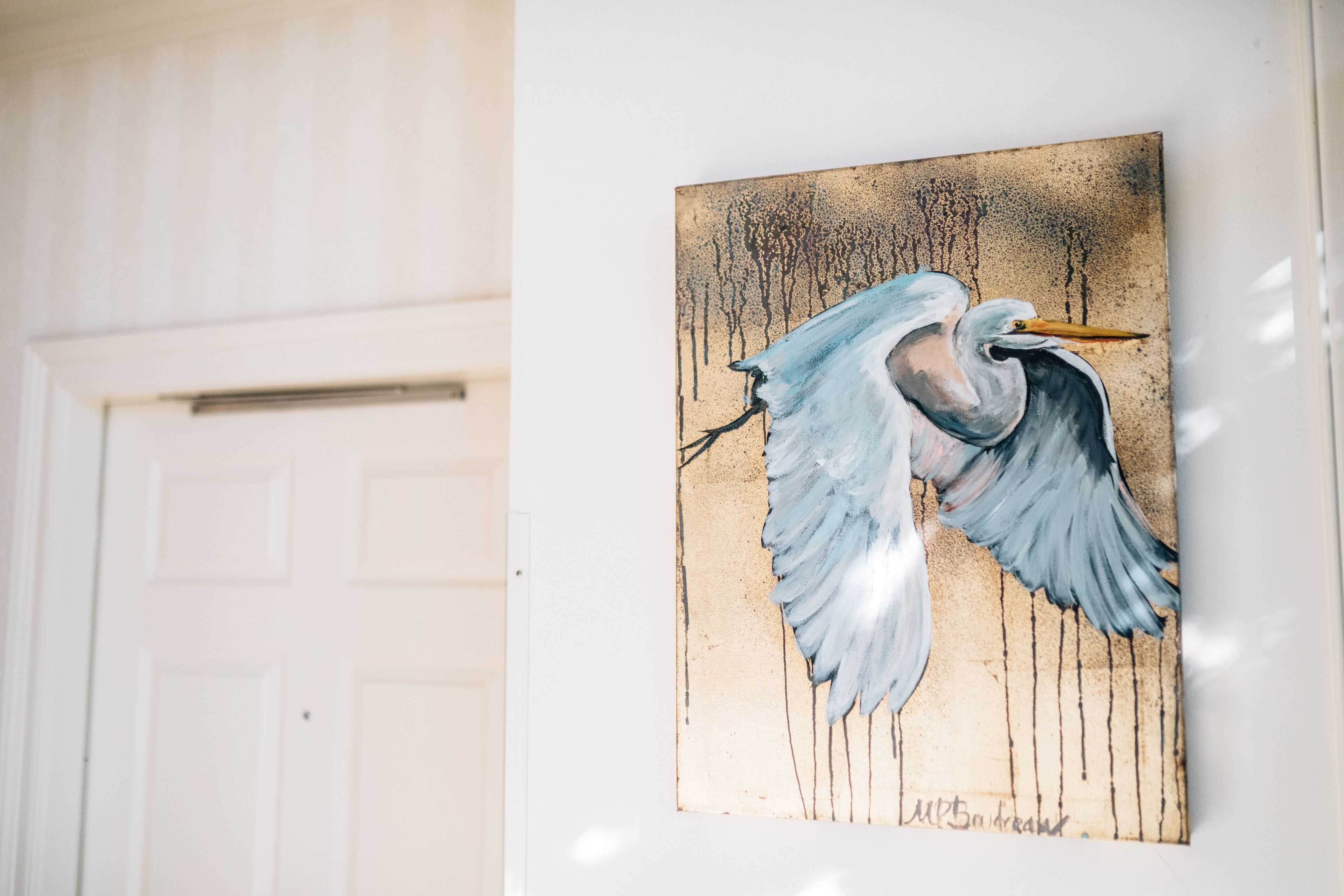 Pintura de um garça em voo na parede.
