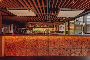 Uma área de bar com teto de madeira e parede de lenha empilhada.