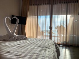 Quarto de hotel com cama, televisão e vista para o exterior.