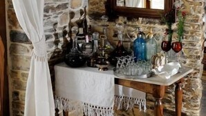 Paredes de pedra com uma mesa de madeira e um espelho.
