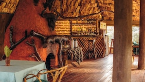 Um interior rústico com um balcão de madeira, lareira e toalha xadrez.