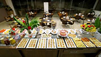 Uma mesa de buffet com diversos alimentos e bebidas.