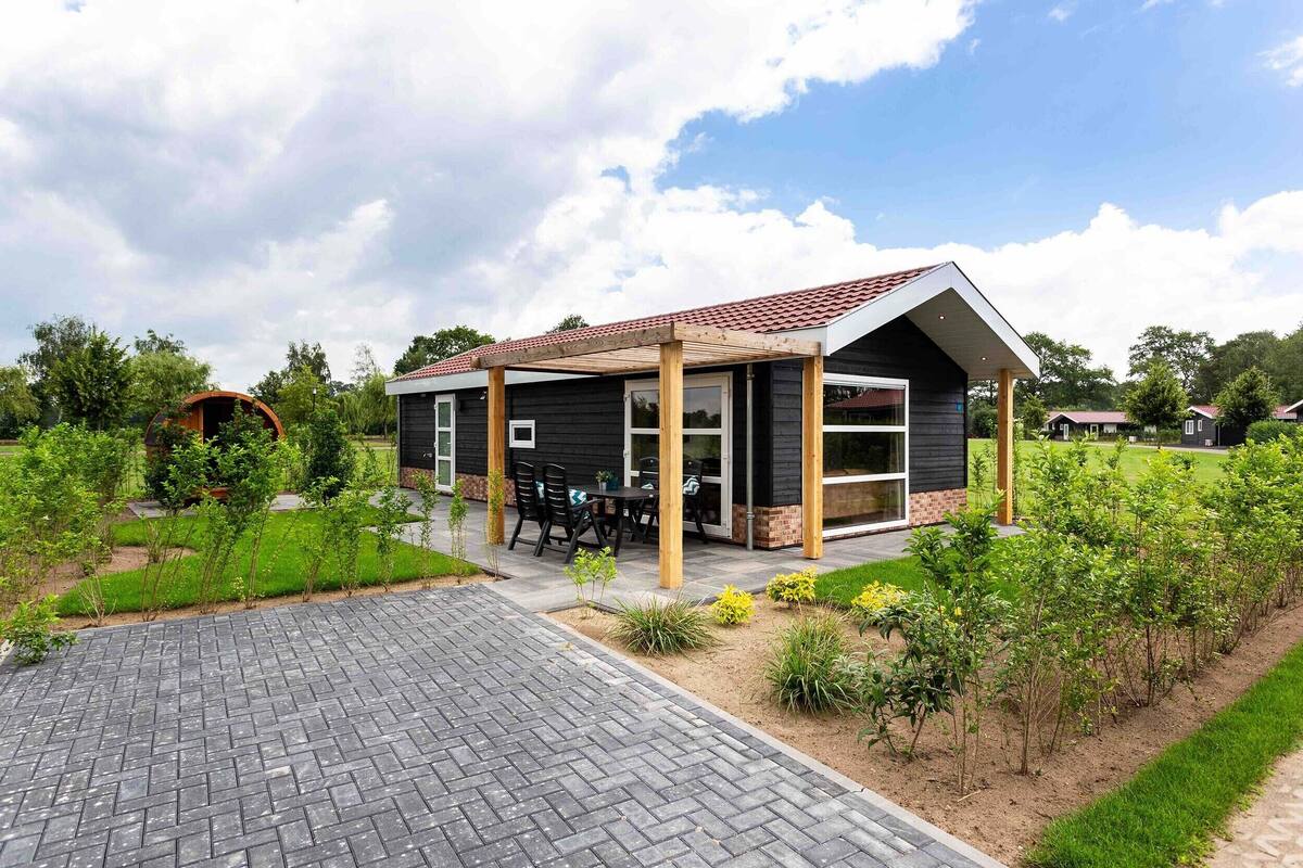Uma casa moderna com varanda coberta, entrada com calçada e jardim bem cuidado.