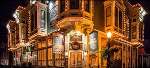 Um edifício em estilo vitoriano com diversas placas indicando que é um local de hospedagem e restaurante, incluindo