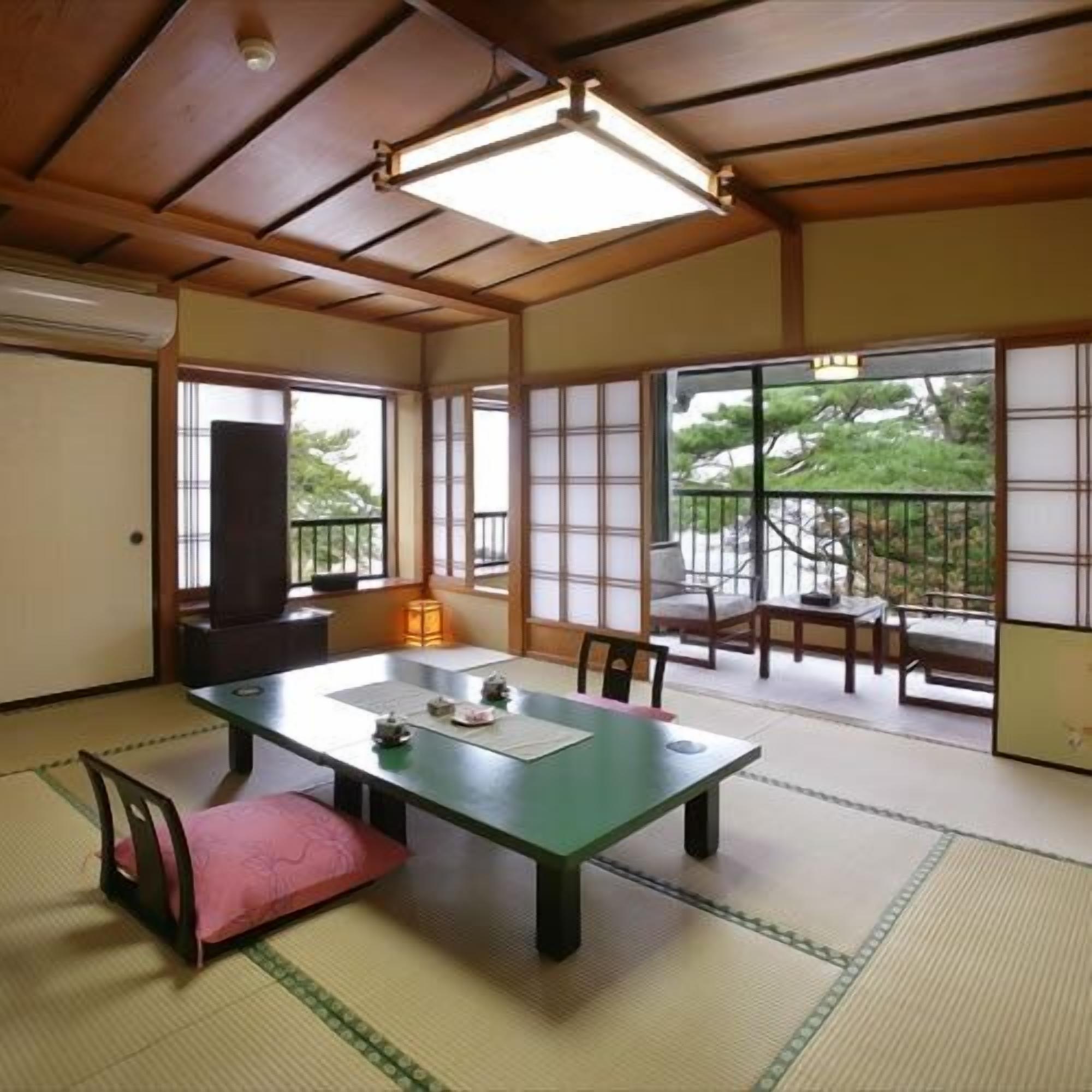 Um quarto japonês tradicional com piso de tatame, uma mesa baixa e portas deslizantes.