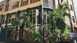 Um edifício de vários andares com design arquitetônico moderno, com grandes janelas e varandas.