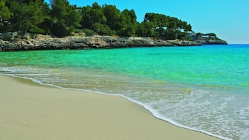 Perto da praia, areia branca, guarda-sóis