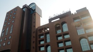 Um edifício com vários andares e uma placa de destaque com a inscrição